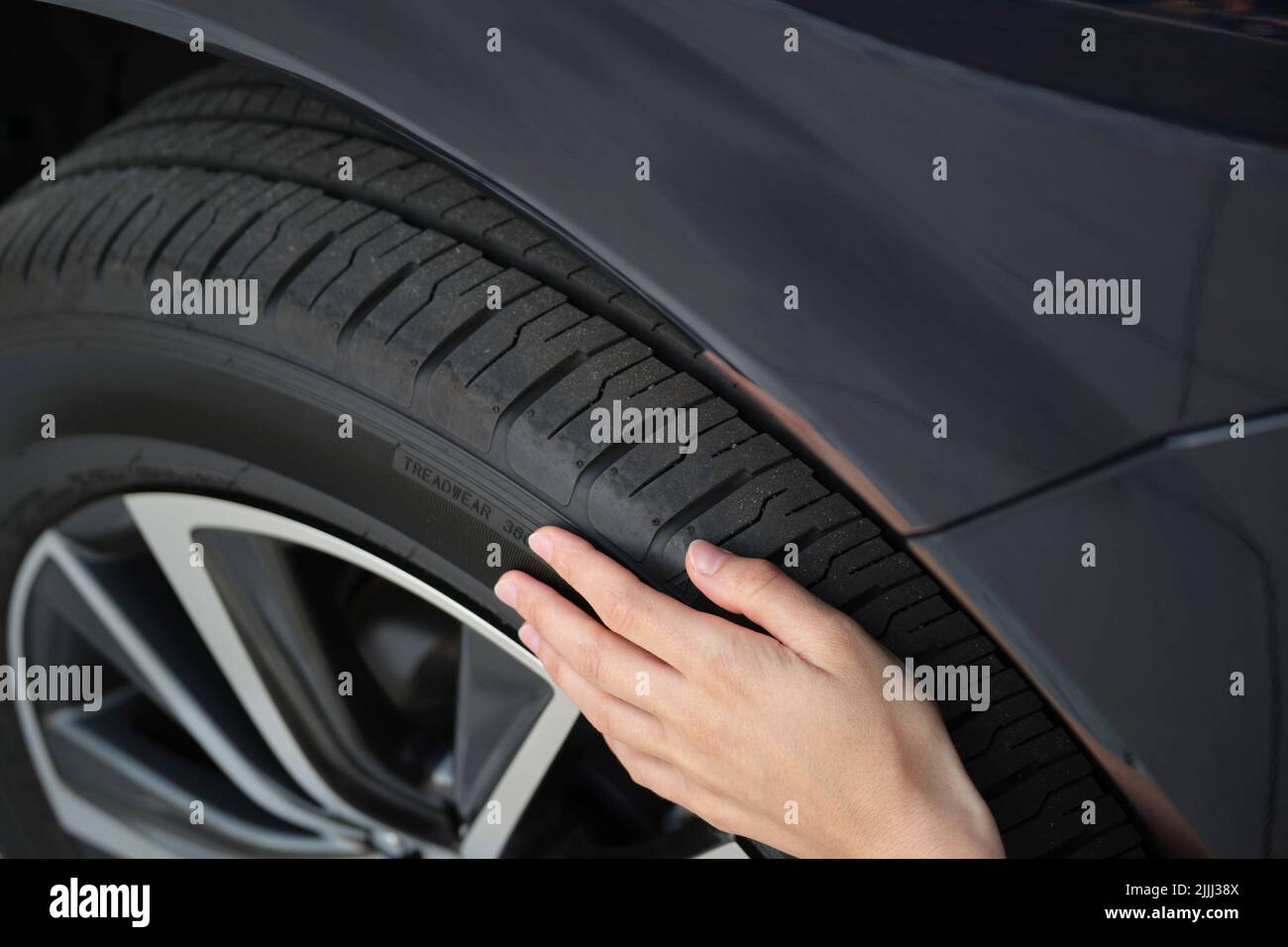 Female driver hands inspecting wheel tire of her new car. Vehicle ...