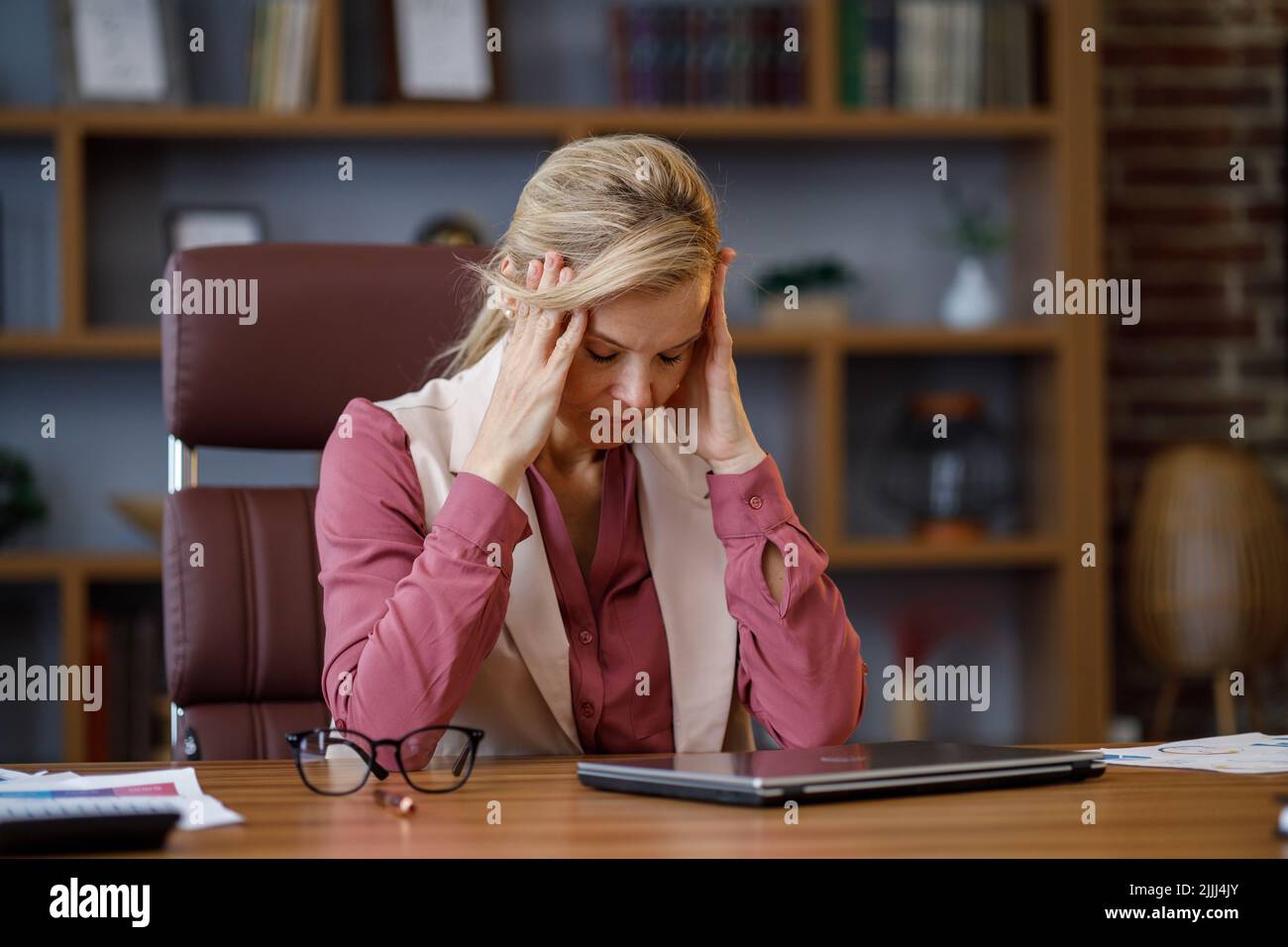 Tired businesswoman after exhausting paperwork taking off eyeglasses ...