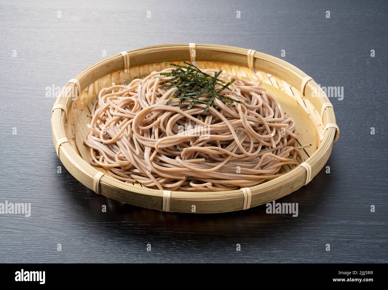 Zaru soba placed against a black background. Zaru soba is a traditional ...