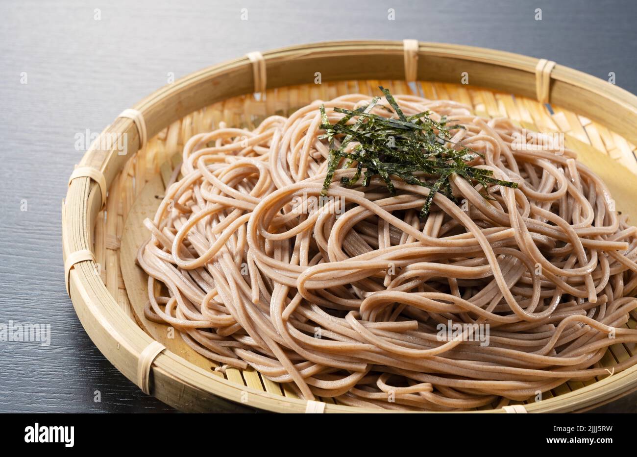 Zaru soba placed against a black background. Zaru soba is a traditional ...