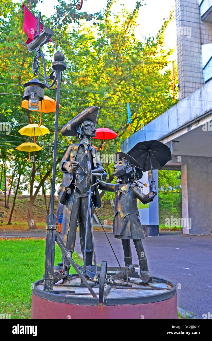 forged metal girl with umbrella and men statue in the Kyiv City ...