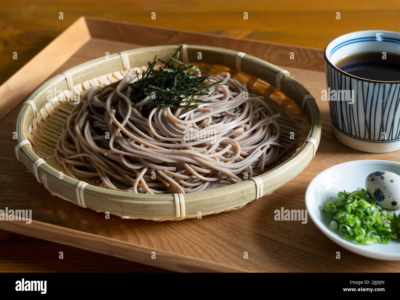 Zaru-soba and condiments on a wooden table. Zaru soba is a traditional ...