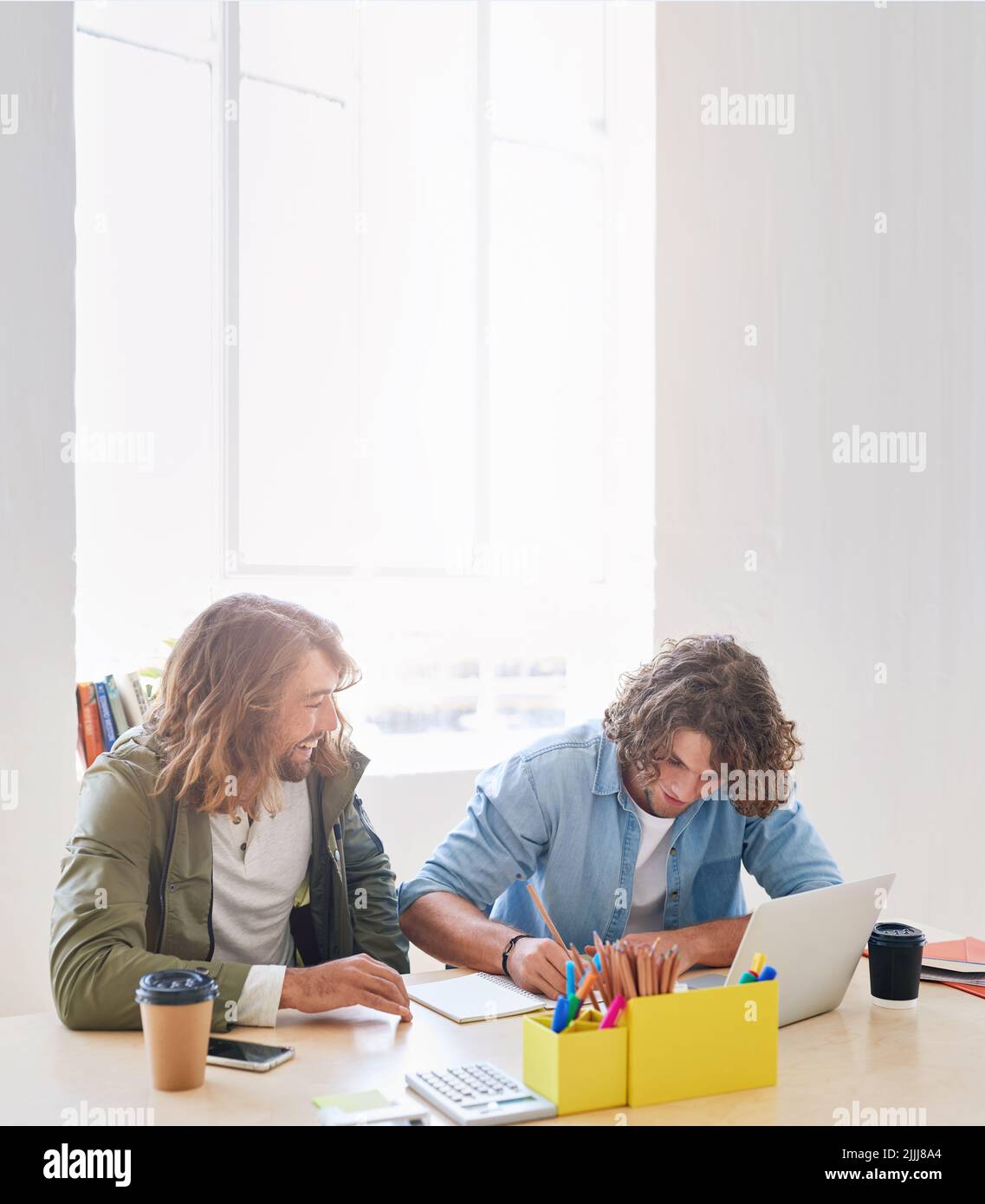 College students working together two young men brainstorming ideas for ...