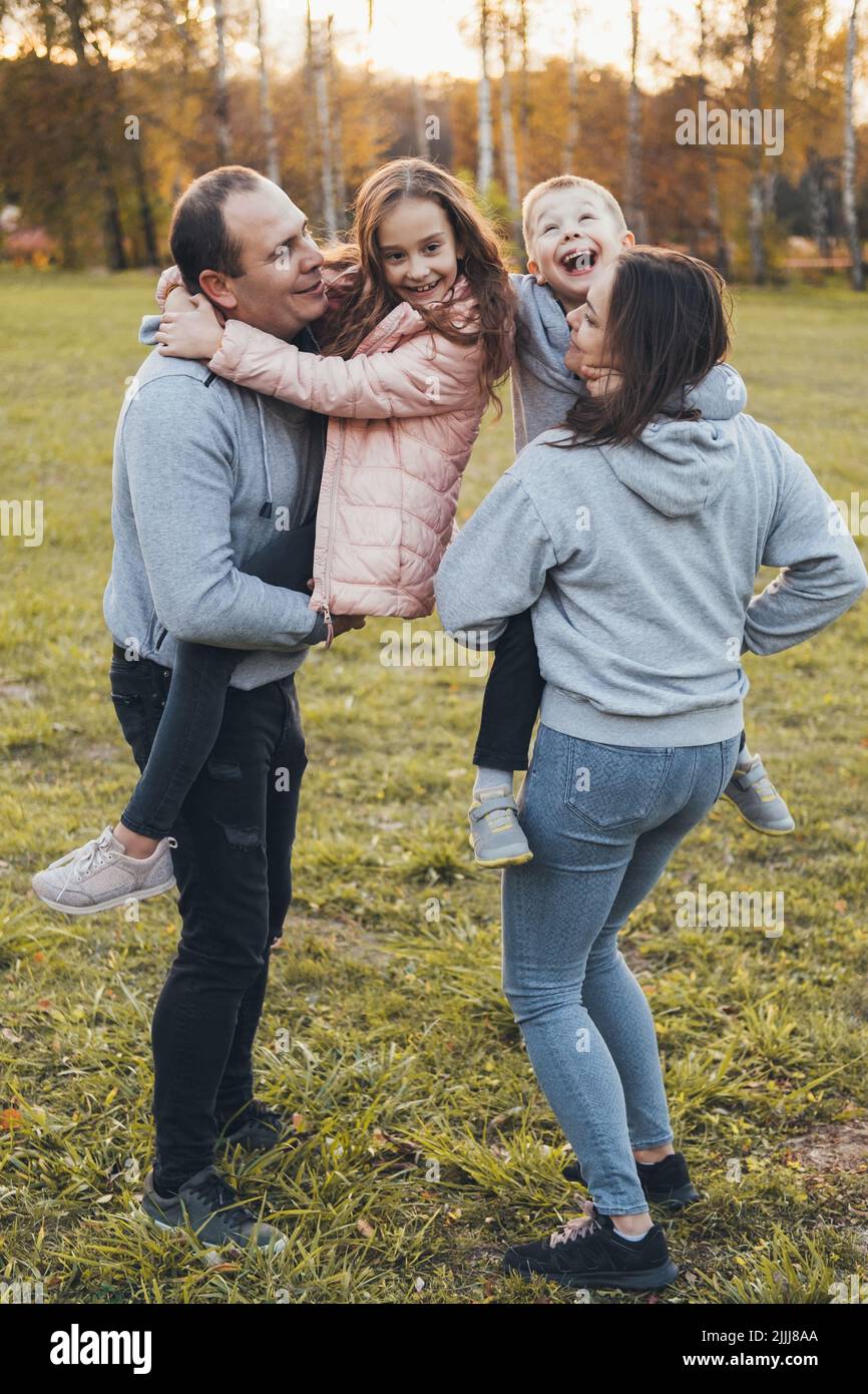 Happy family having fun outdoors in the park while posing together ...