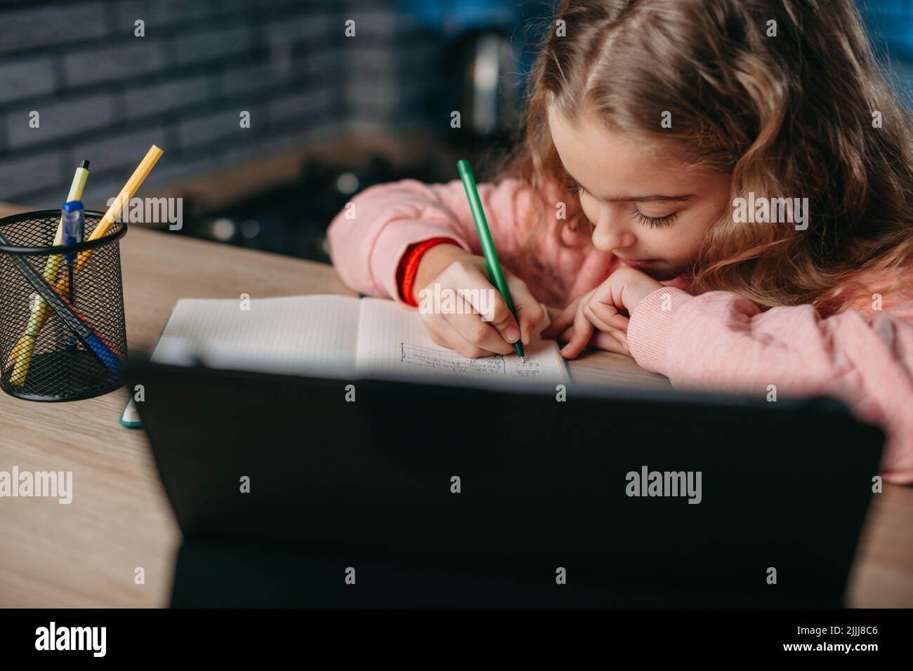 Caucasian schoolgirl studying remotely on tablet, preparing for exam at ...