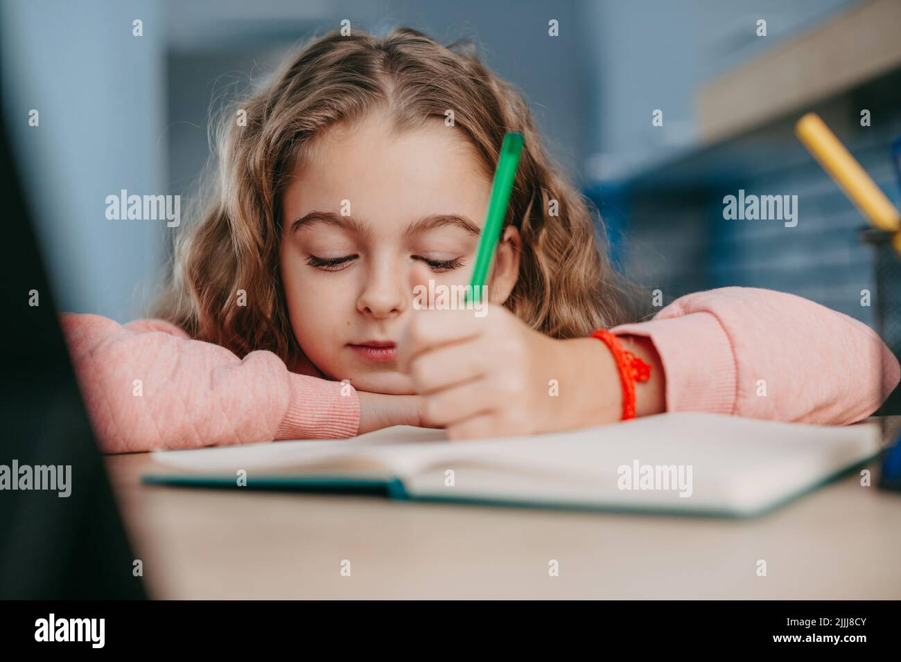 Teenage girl writing to notebook at home, using tablet. Student ...