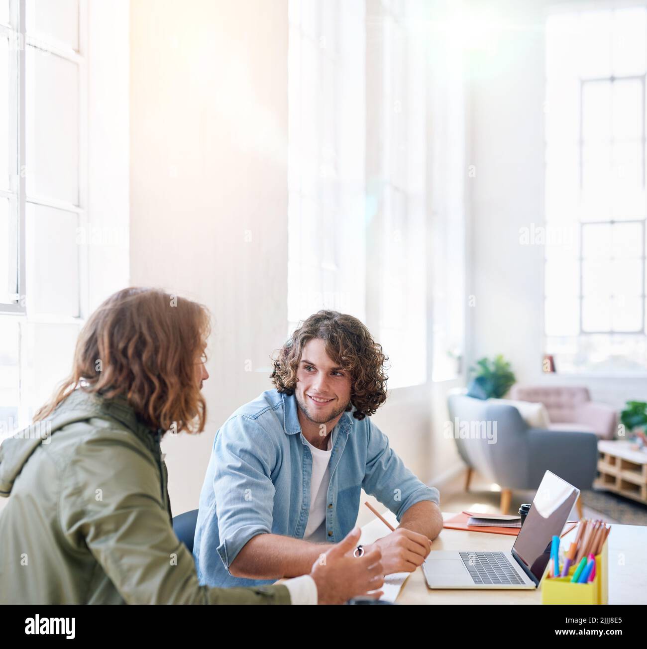 College students working together two young men brainstorming ideas for ...