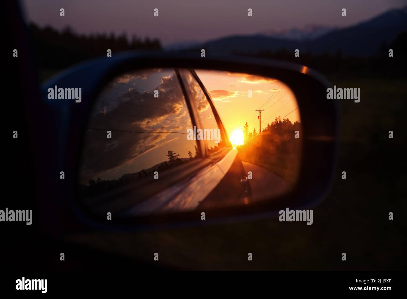 Beautiful sunset in sideview car mirror on mountain road Stock Photo ...