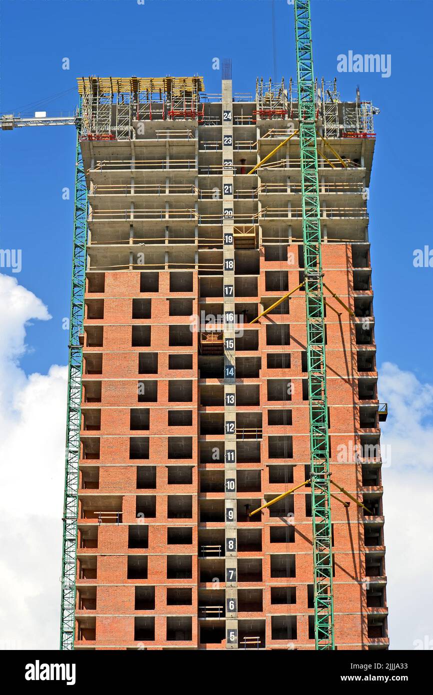high skyscraper with empty windows on blue sky with clouds in sunny day ...