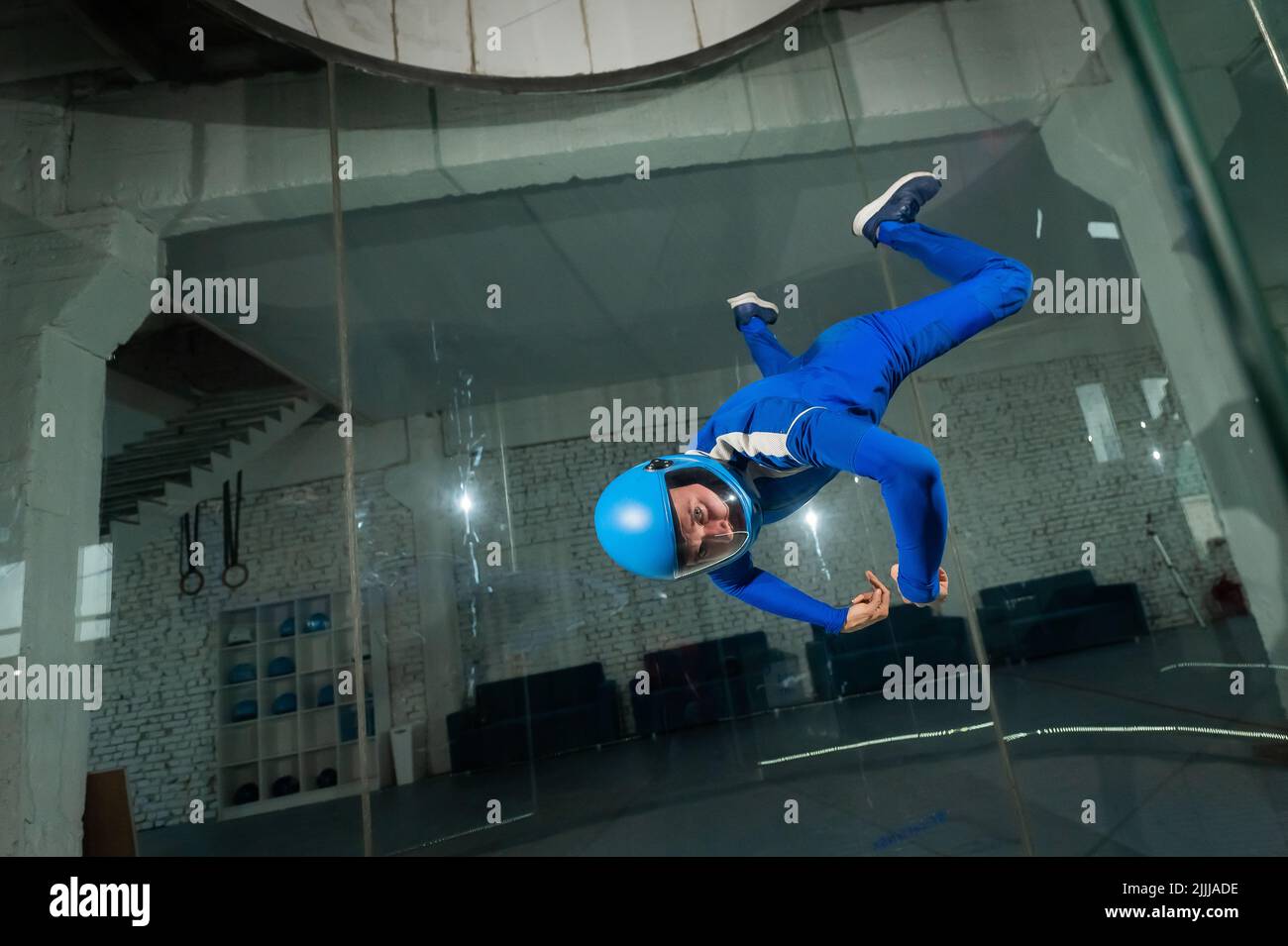 A man in overalls and a protective helmet enjoys flying in a wind ...