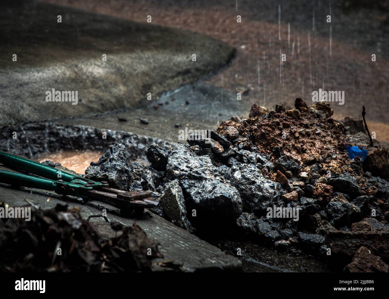 Broken leak water pipe busting at front of home during rain. Visible ...