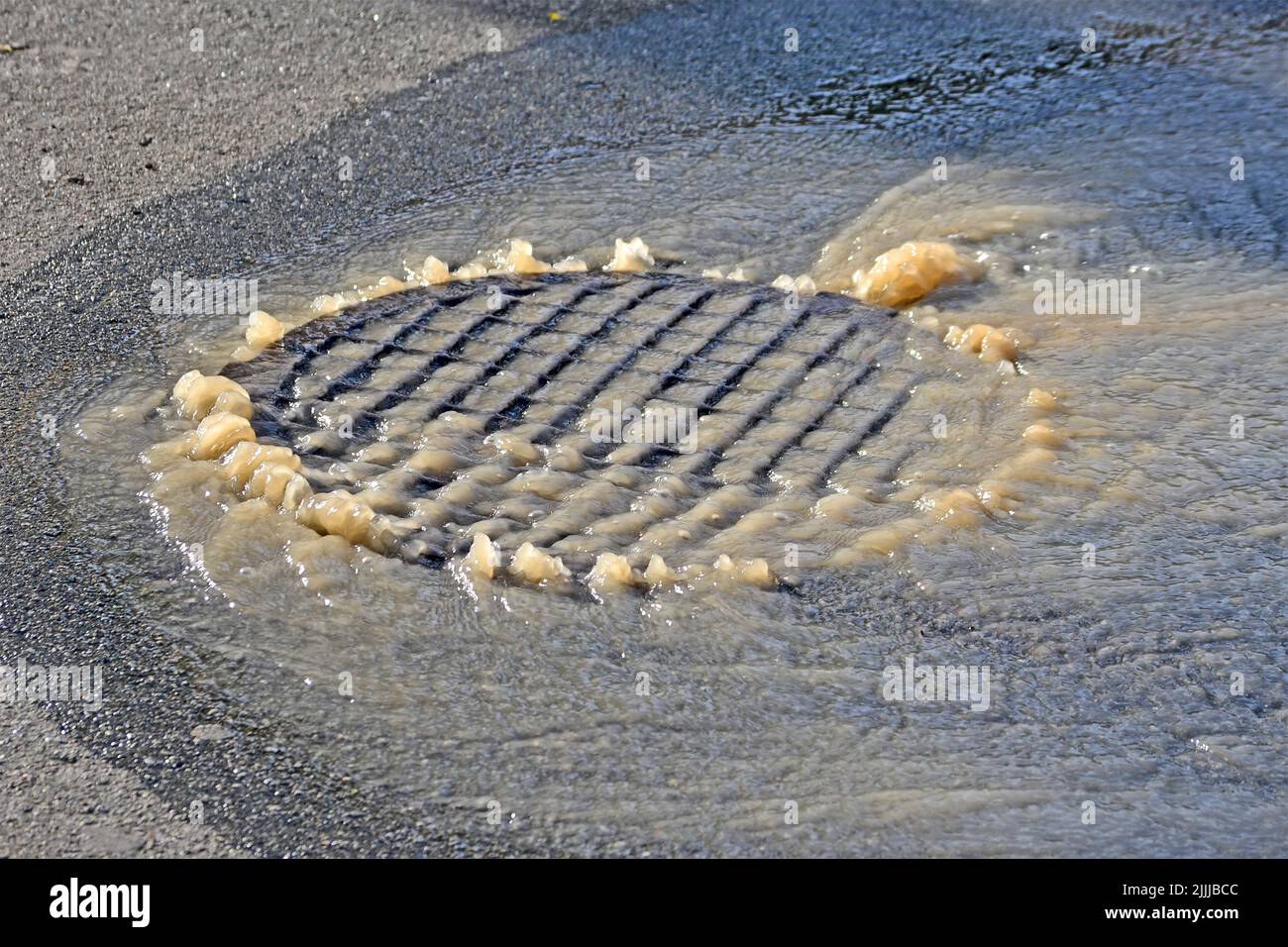 grunge water flow under vintage metal manhole (breakthrough aka ...