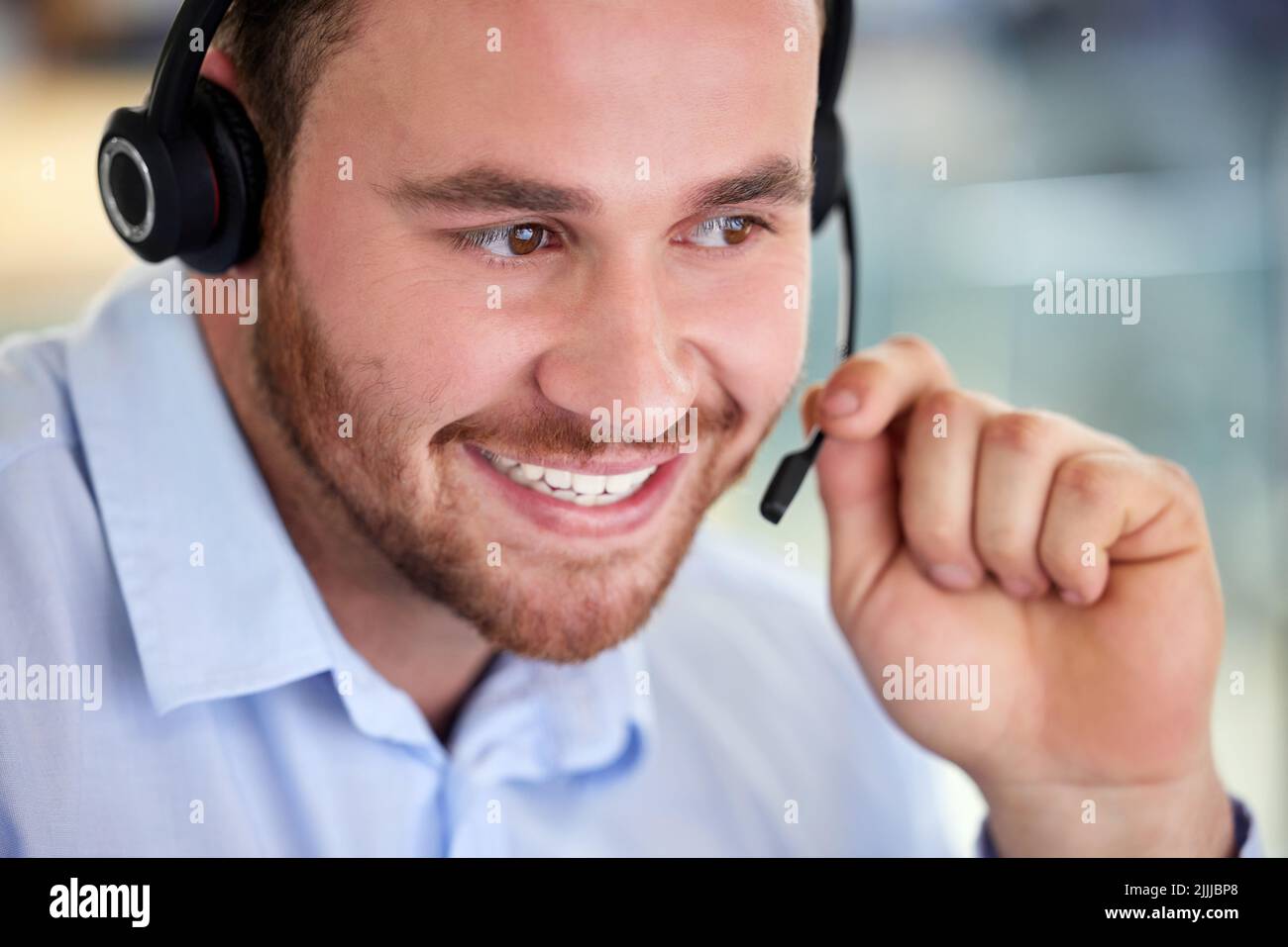 Professional assistance at your service. a young man using a headset in ...