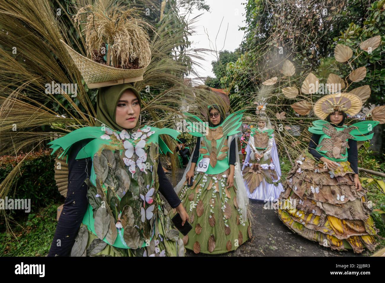 A woman in nature dress made from leaves, flowers, roots, participate ...