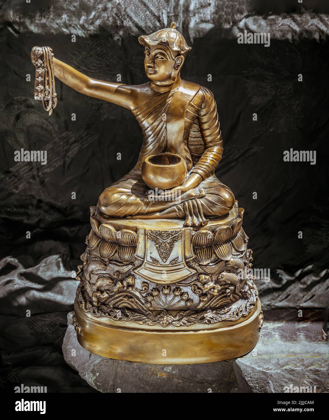Bronze figurine of Phra upagupta or Phra bua khem statue on dark ...