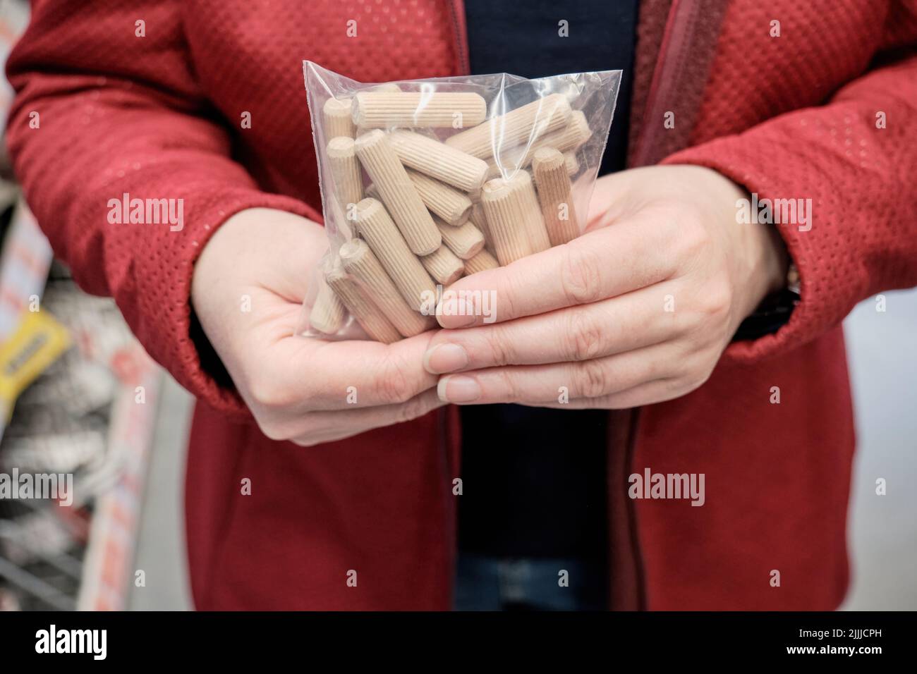 Woman in building materials store chooses for buy wooden dowels for ...