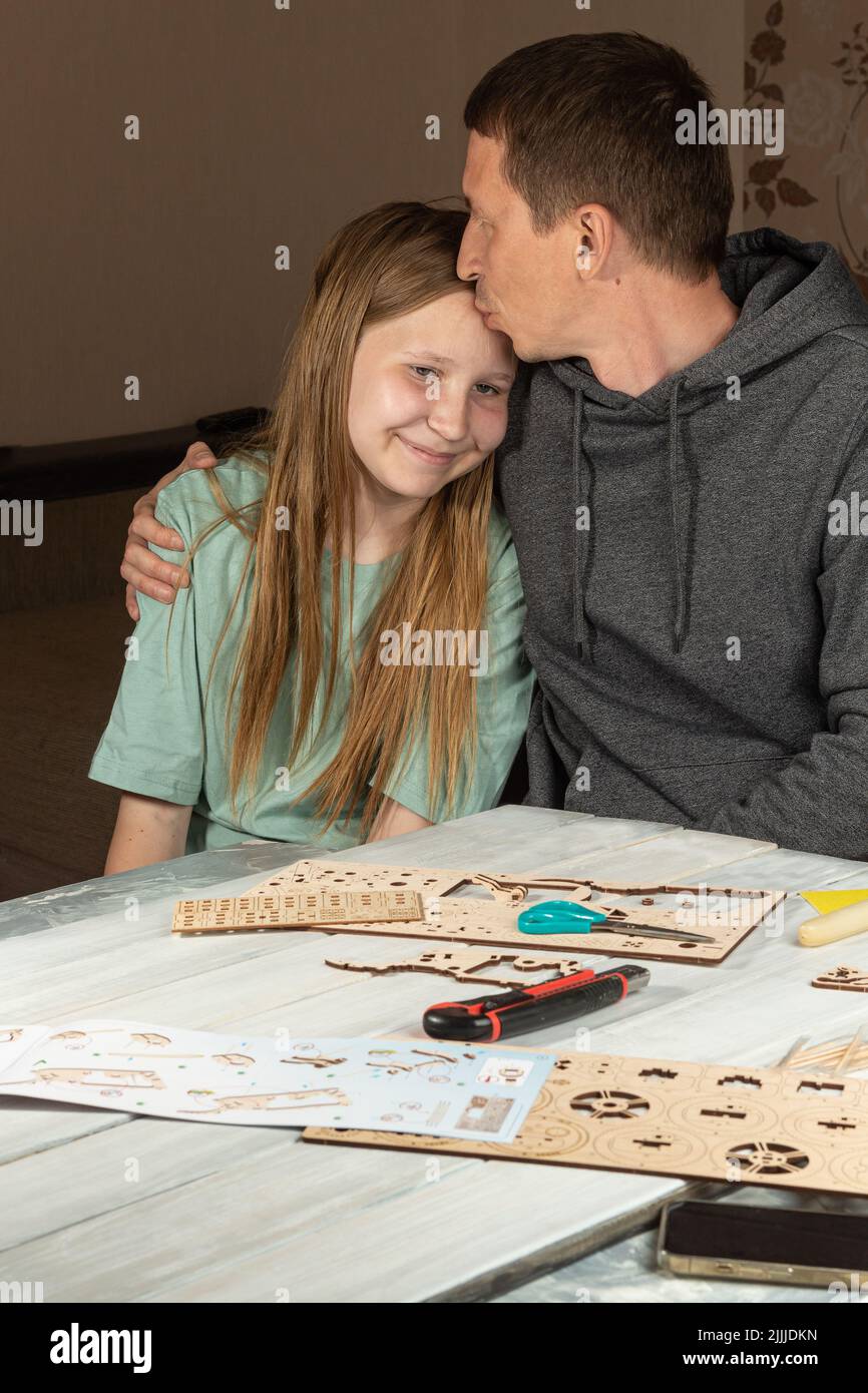 Dad and teenage daughter work together on DIY homework project. Dad ...