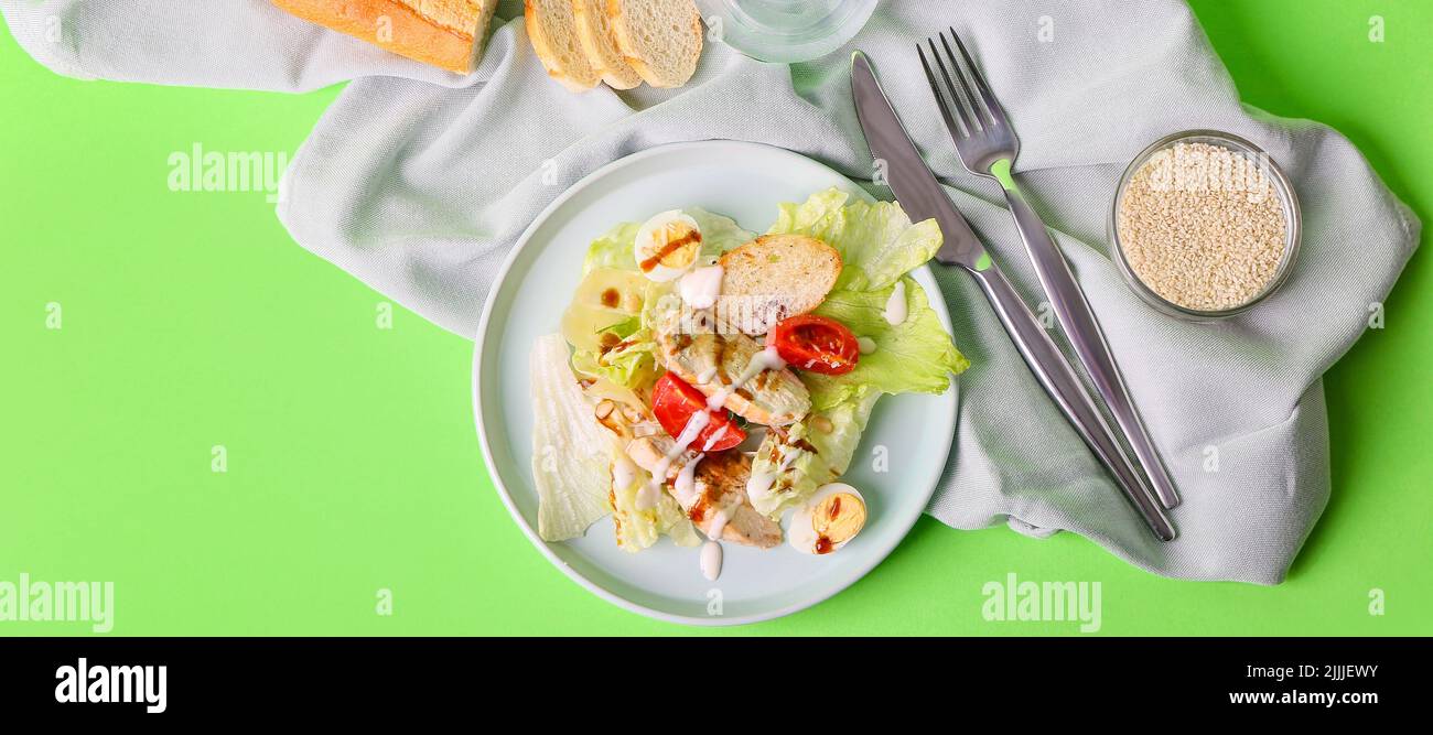 Plate of fresh Caesar salad on green background Stock Photo - Alamy