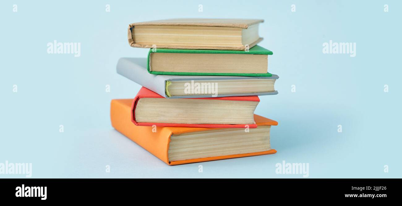 Stack of books on light blue background Stock Photo - Alamy