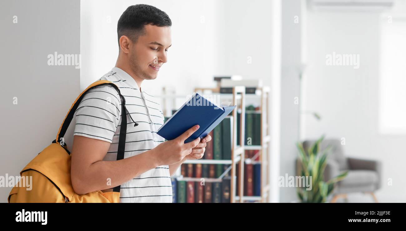 Male student reading book in library Stock Photo - Alamy