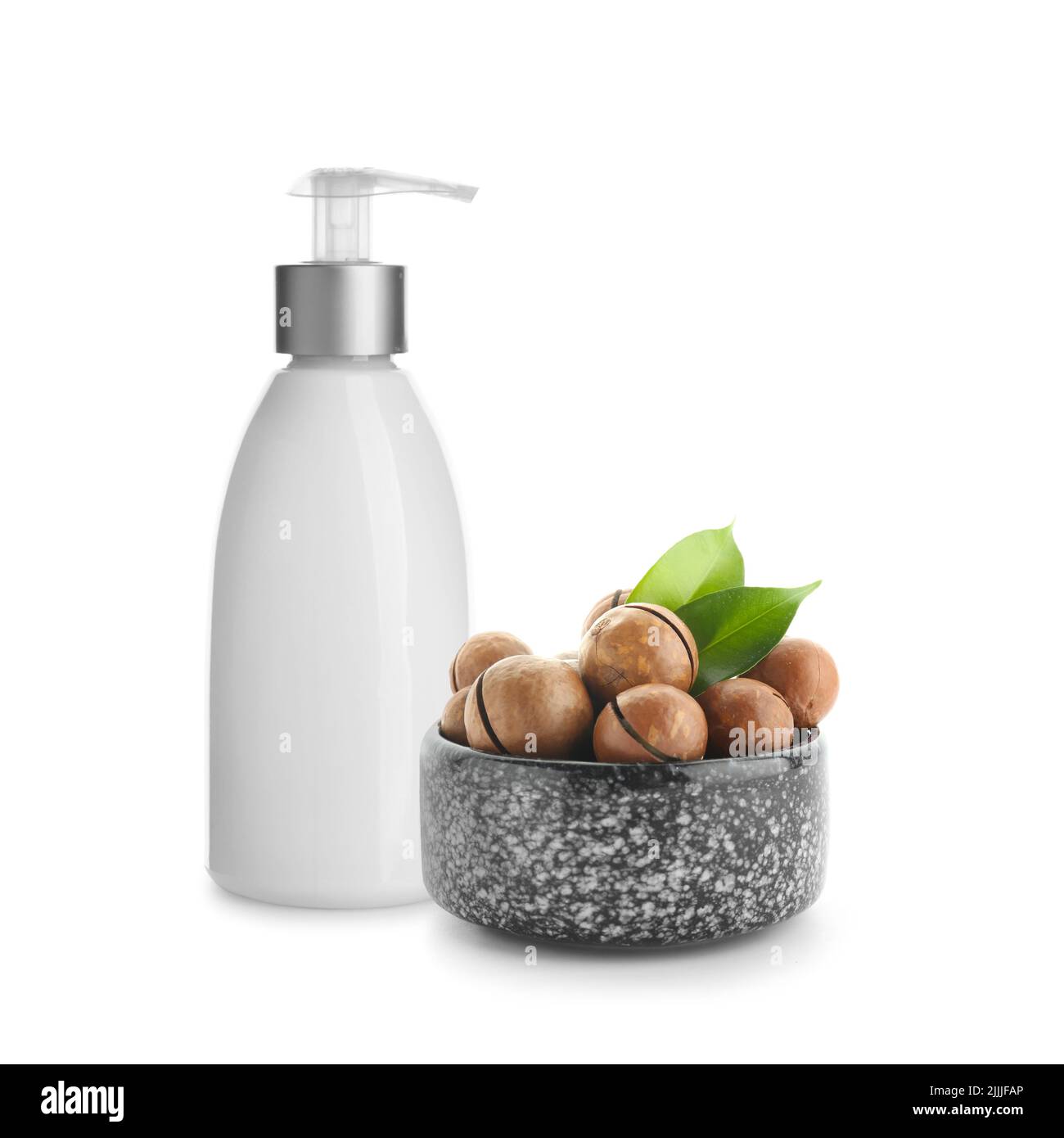 Bottle of natural cosmetics with macadamia nuts in bowl on white ...