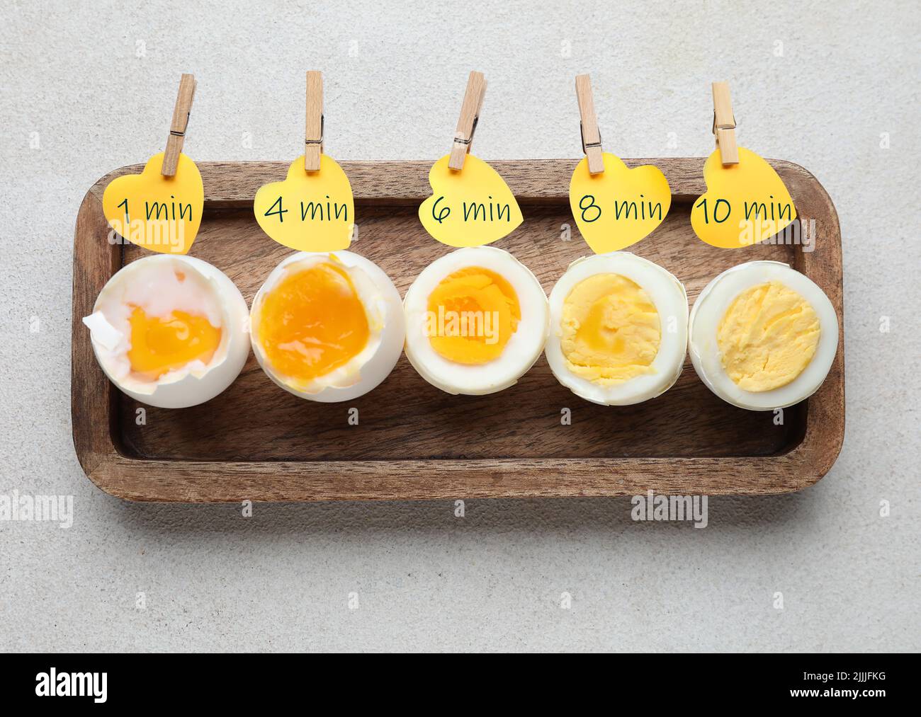 Timing of boiling eggs on grey background Stock Photo - Alamy