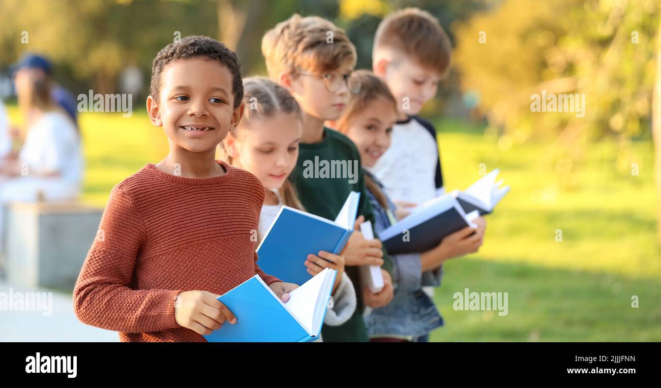 Cute little children reading books in park Stock Photo - Alamy