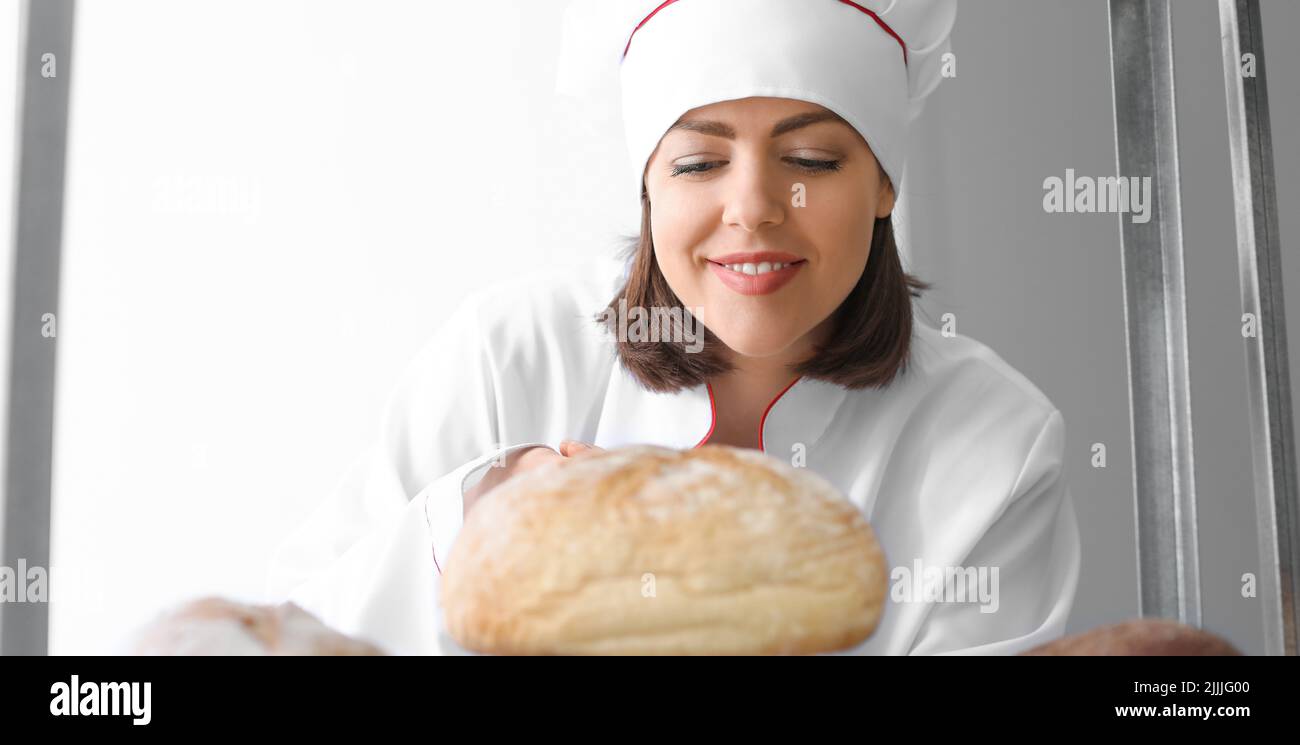 Female baker with fresh bread in kitchen Stock Photo - Alamy