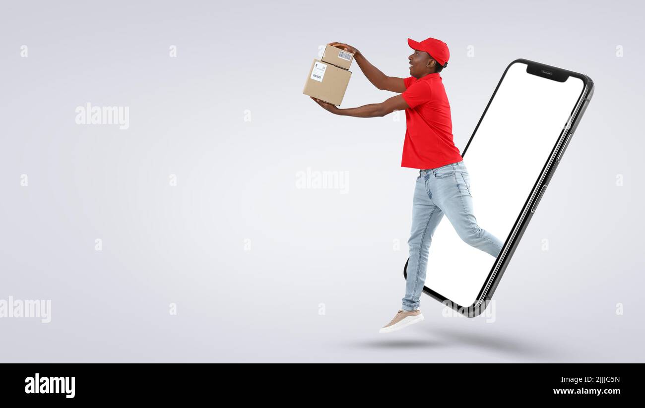 African-American courier with parcels jumping out of big smartphone ...