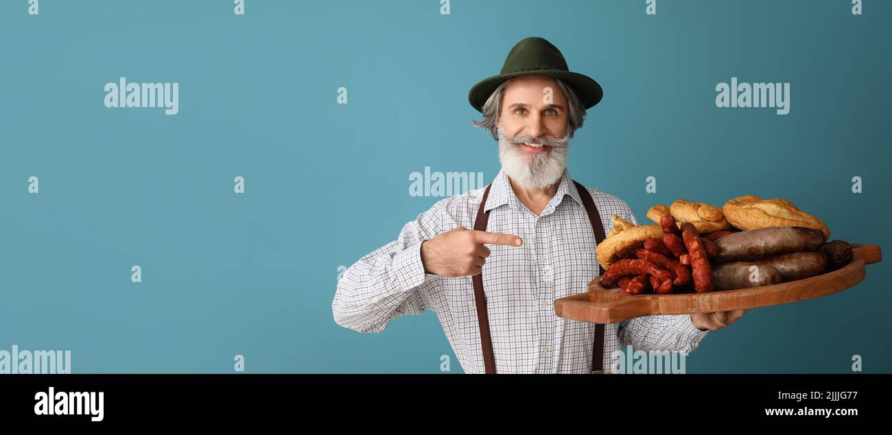 Handsome man in traditional German clothes and with snacks on blue ...