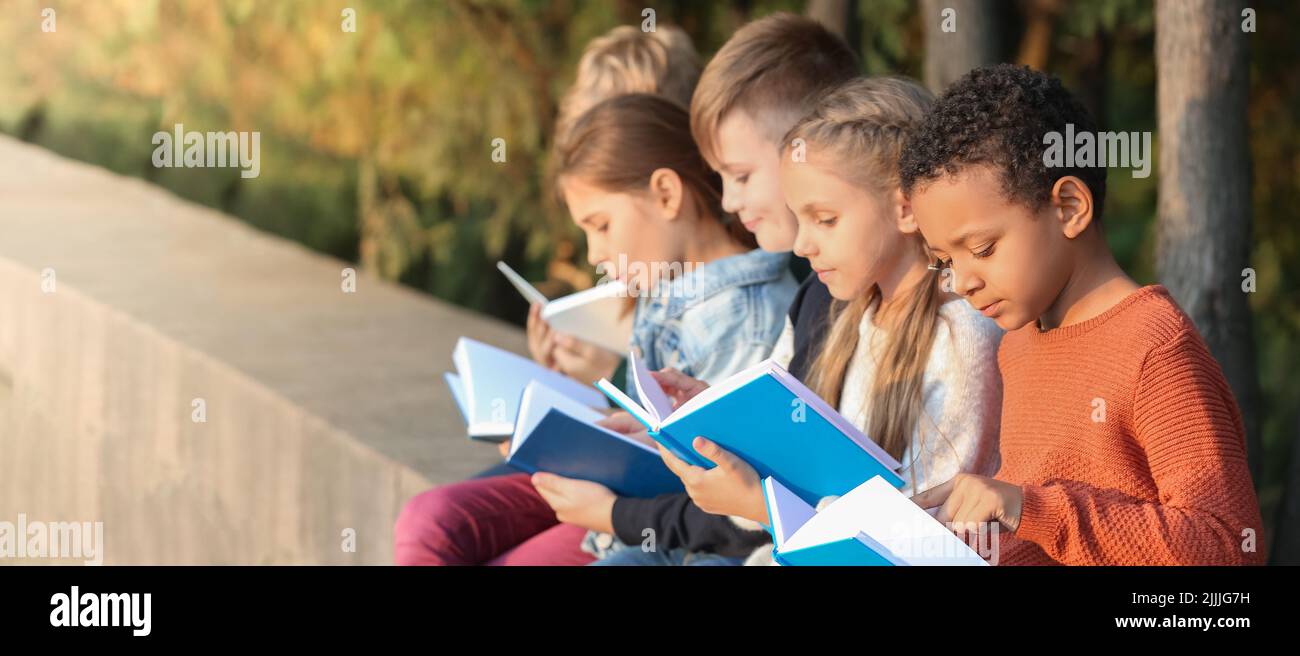 Cute little children reading books in park Stock Photo - Alamy