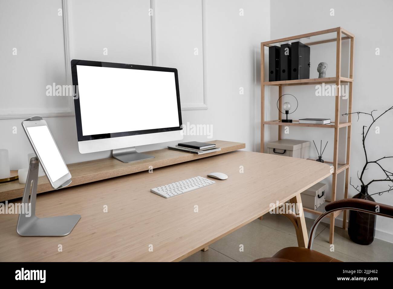 Modern workplace with computer and tablet near light wall Stock Photo ...