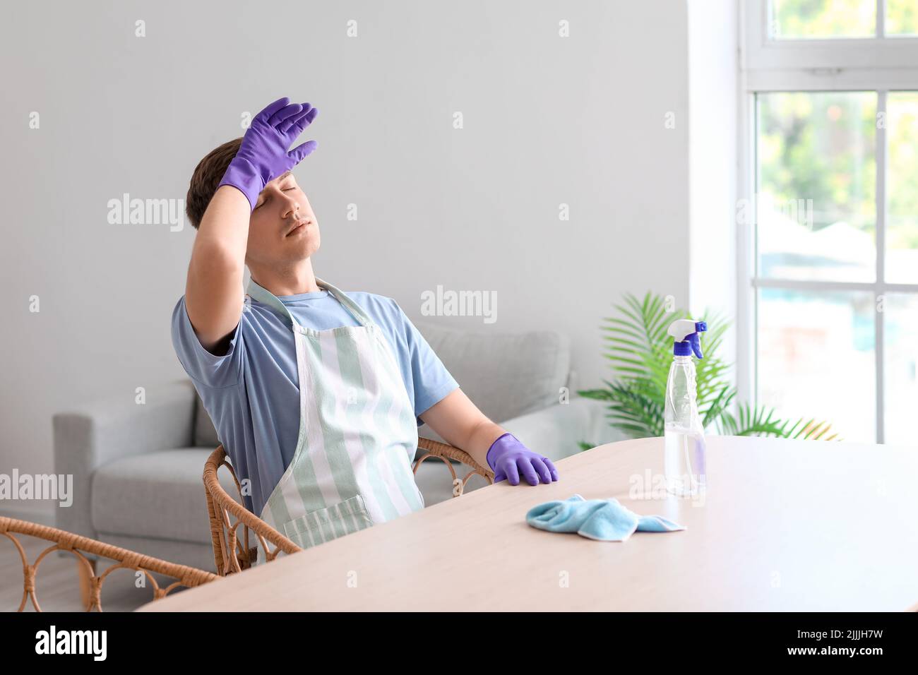 Tired young man after cleaning dining table in kitchen Stock Photo - Alamy
