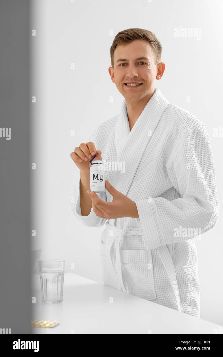 Young man with bottle of magnesium pills in bathroom Stock Photo - Alamy