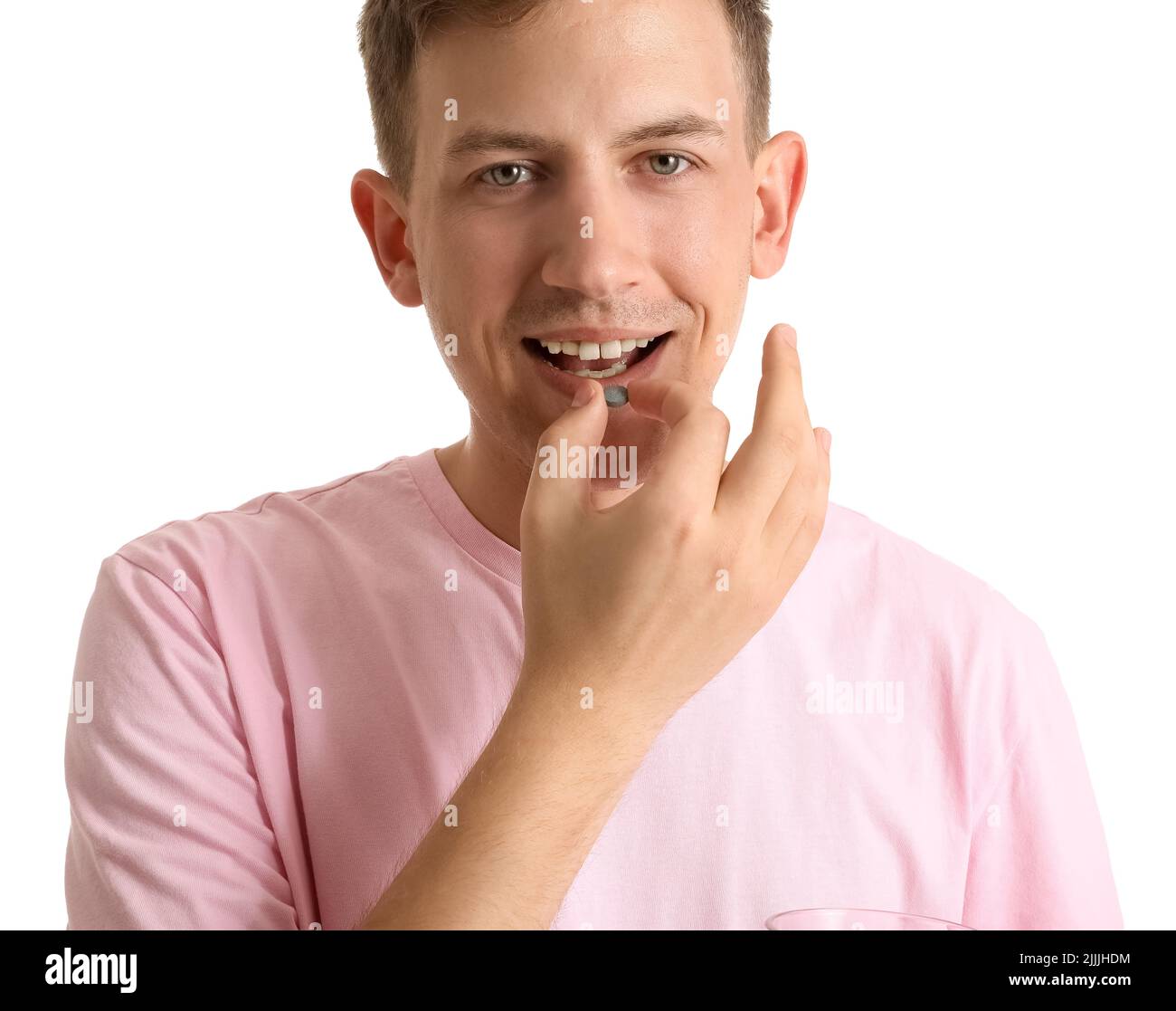 Young man taking vitamin on white background Stock Photo - Alamy