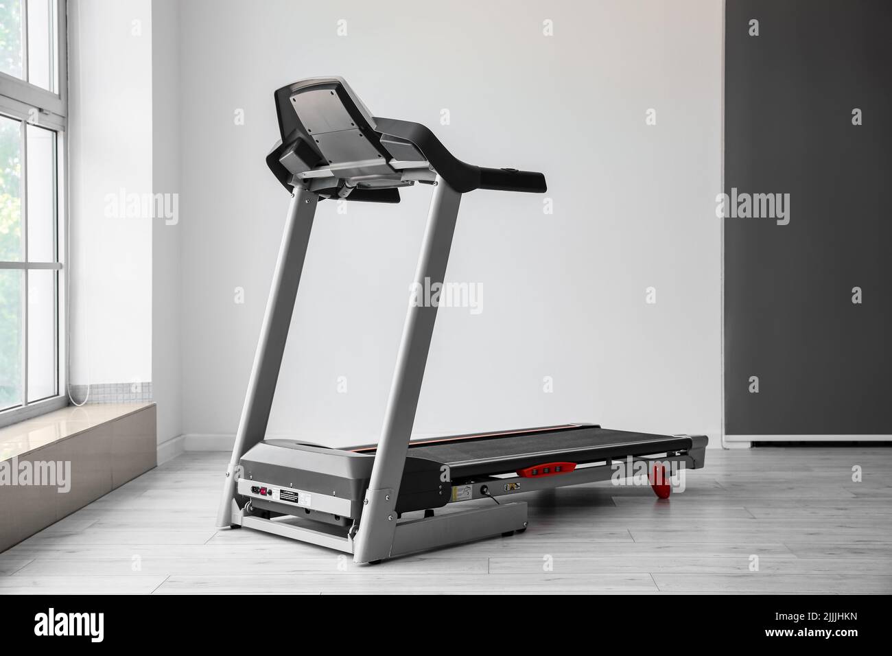 Modern treadmill near light wall in room Stock Photo - Alamy