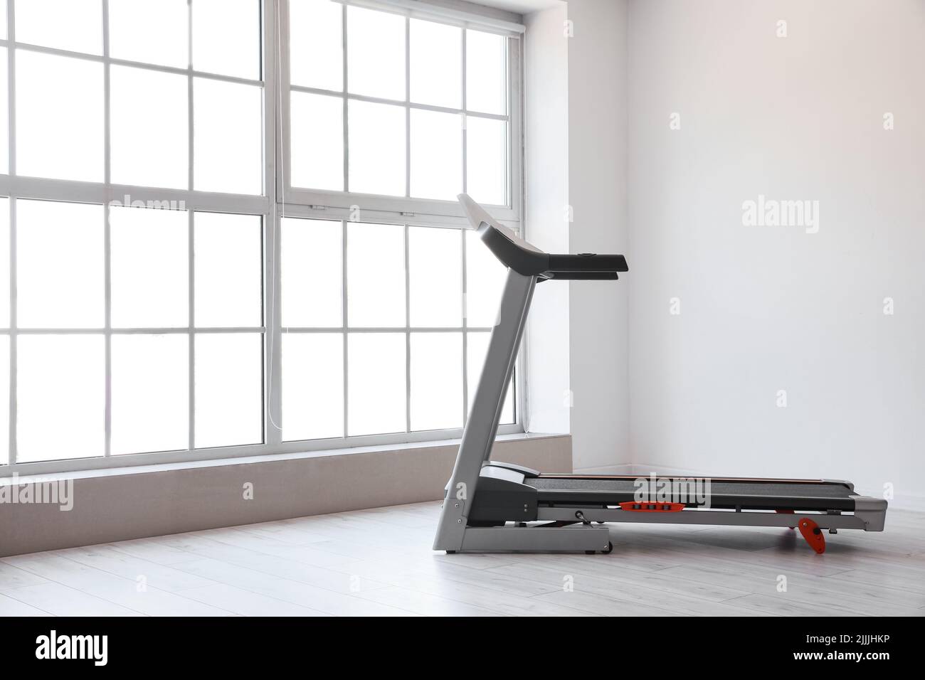 Modern treadmill near window in room Stock Photo - Alamy