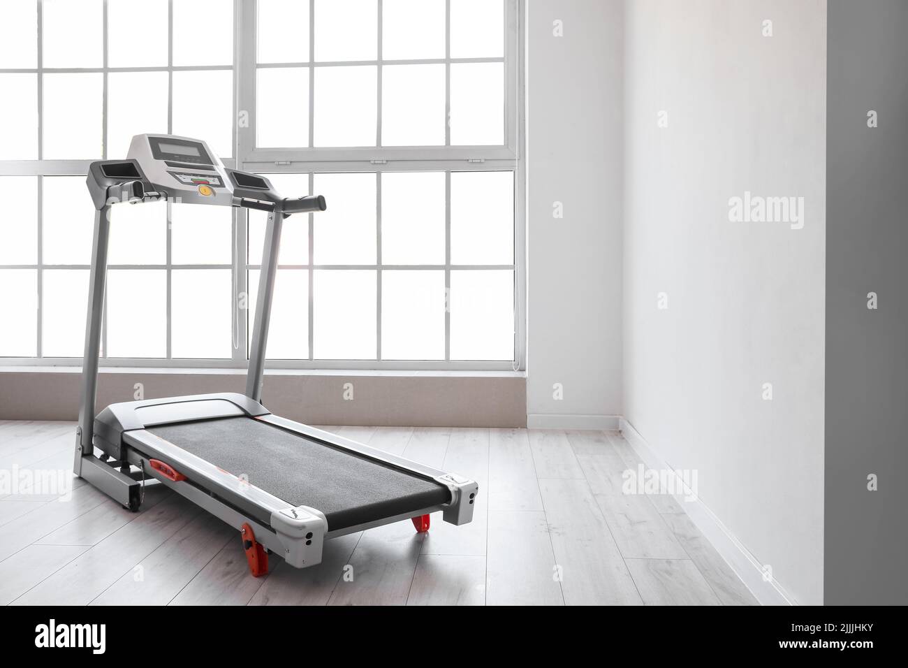 Modern treadmill near window in room Stock Photo - Alamy