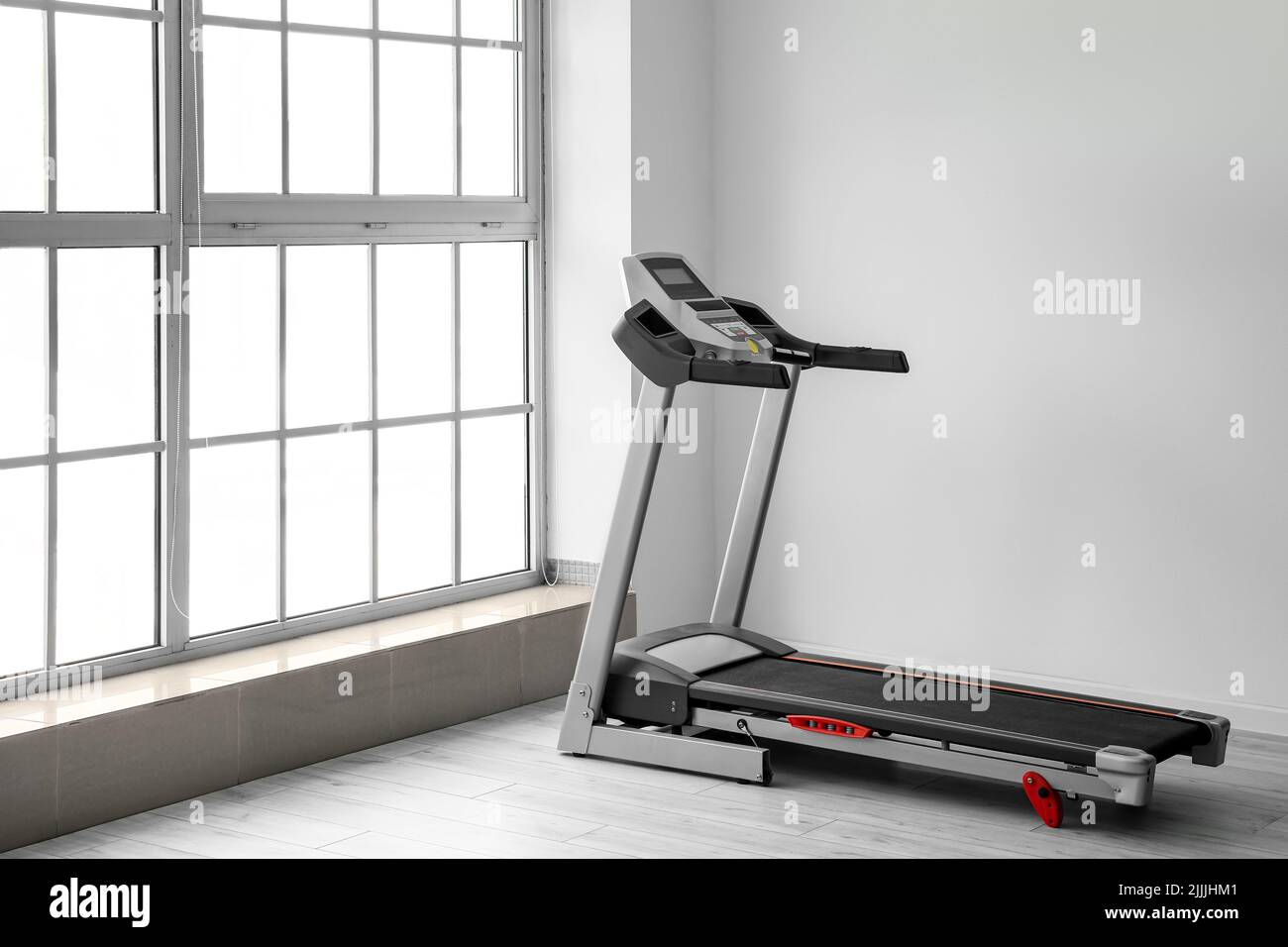 Modern treadmill near window in room Stock Photo - Alamy