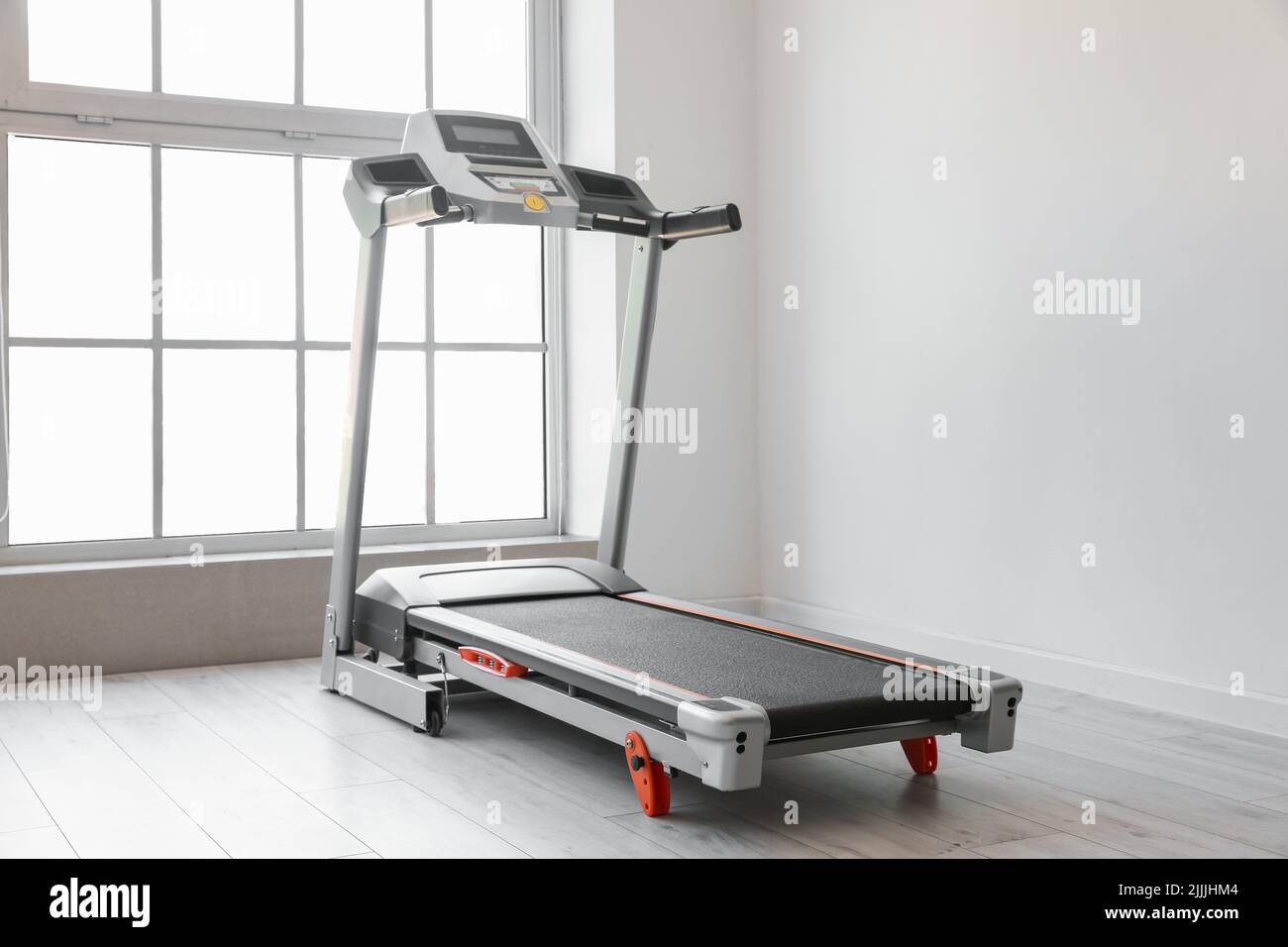 Modern treadmill near window in room Stock Photo - Alamy