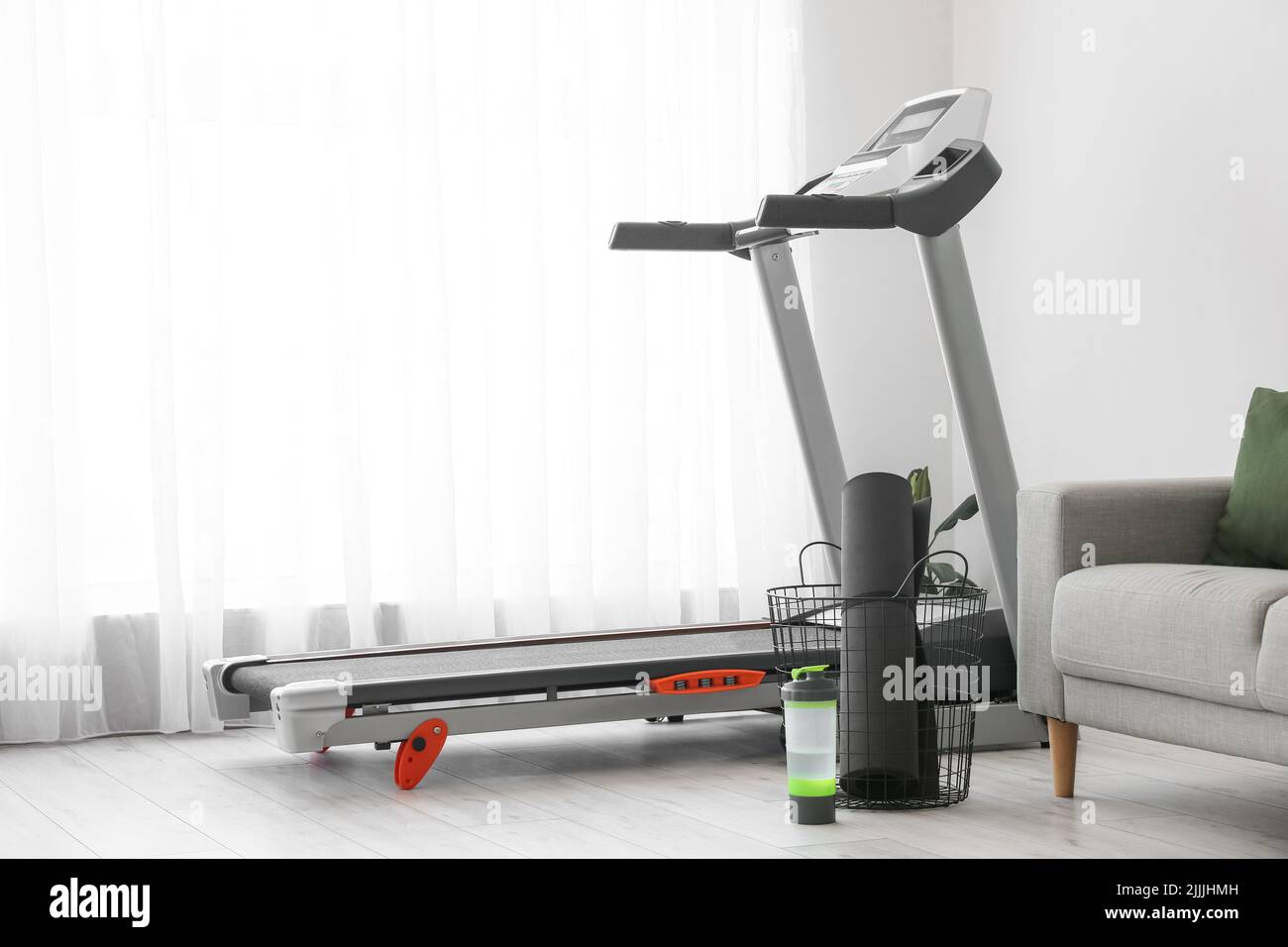 Modern treadmill in interior of light living room Stock Photo - Alamy