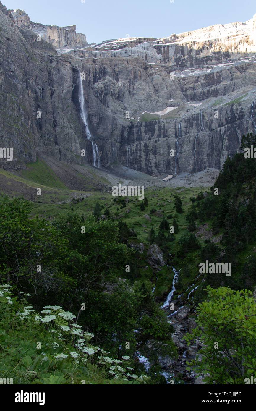 A vertical shot of a waterfall going down the cliff in the Cirque de ...