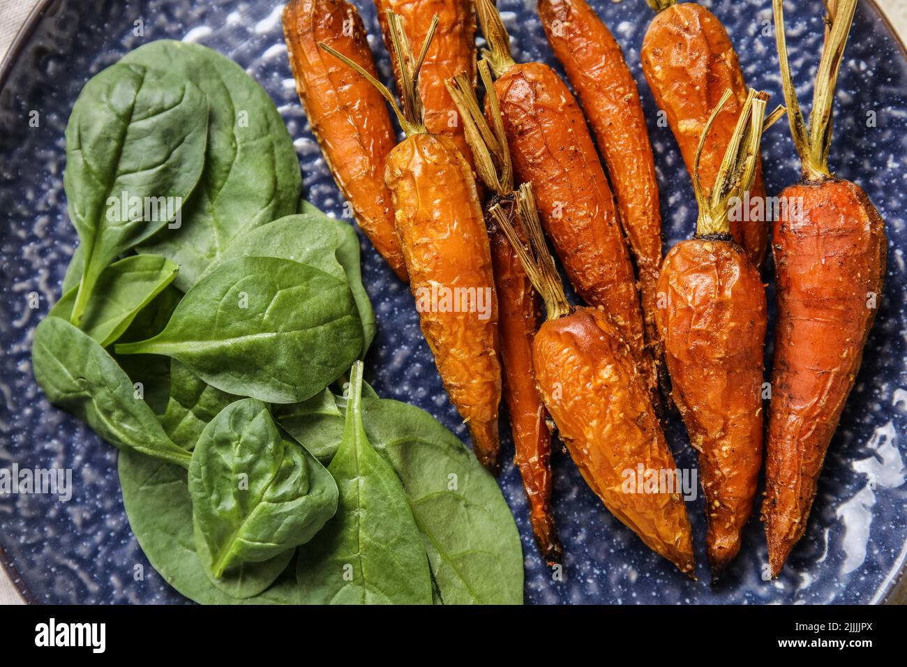 Plate of tasty baked carrots and spinach, closeup Stock Photo - Alamy