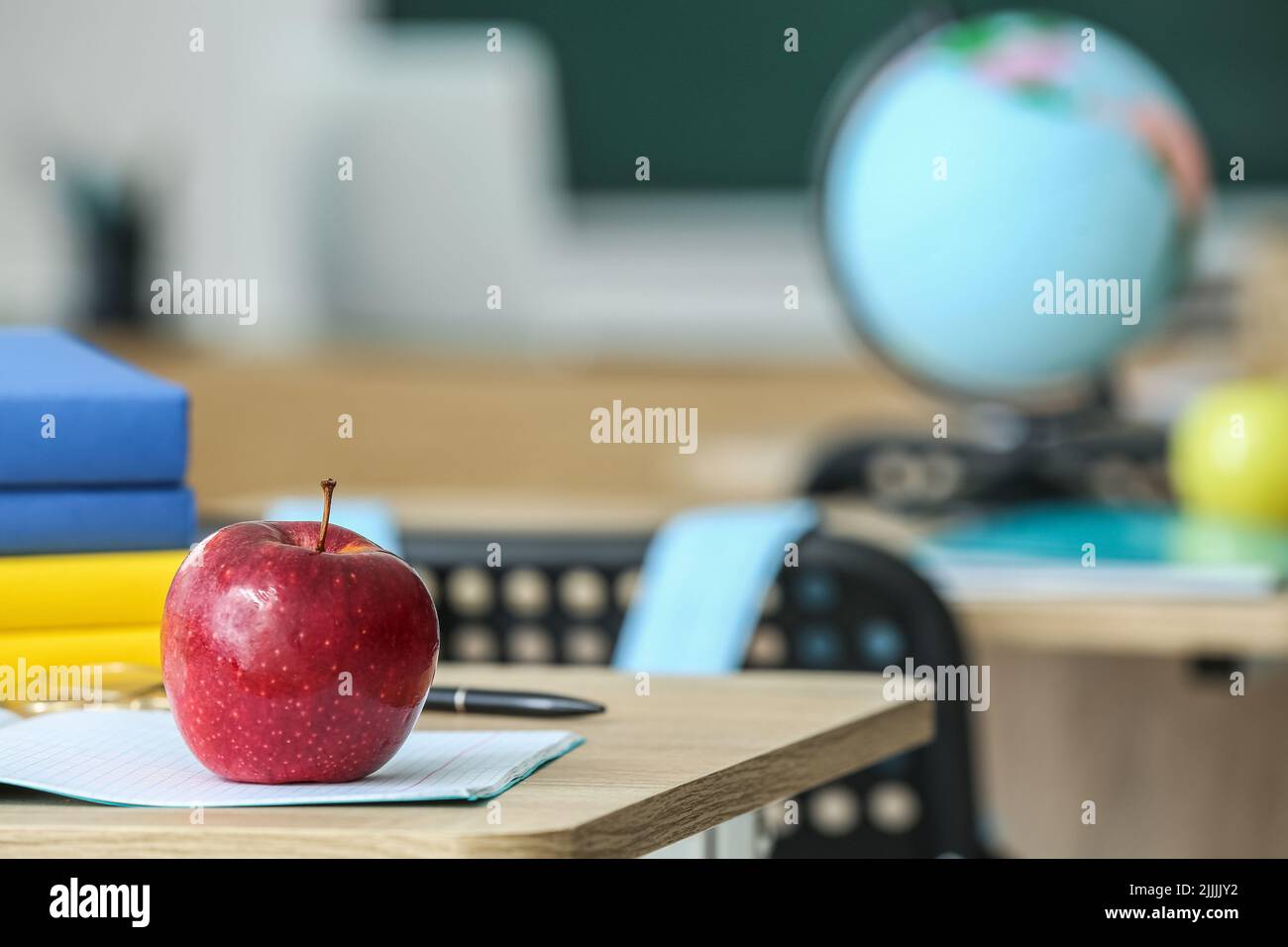 Apple with school books on table in classroom, closeup Stock Photo - Alamy