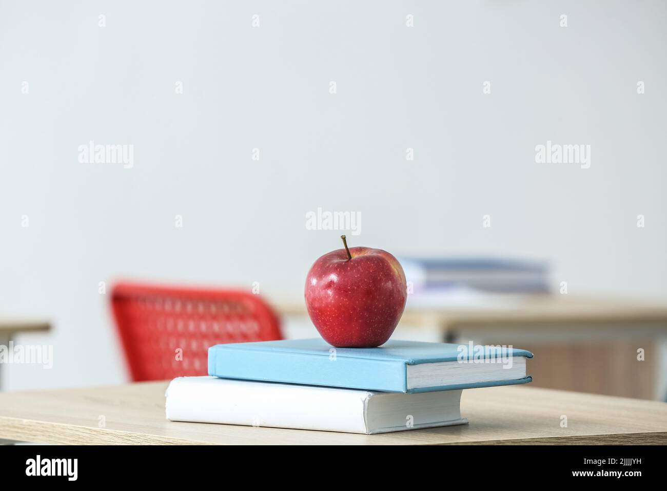 Apple with school books on table in classroom, closeup Stock Photo - Alamy