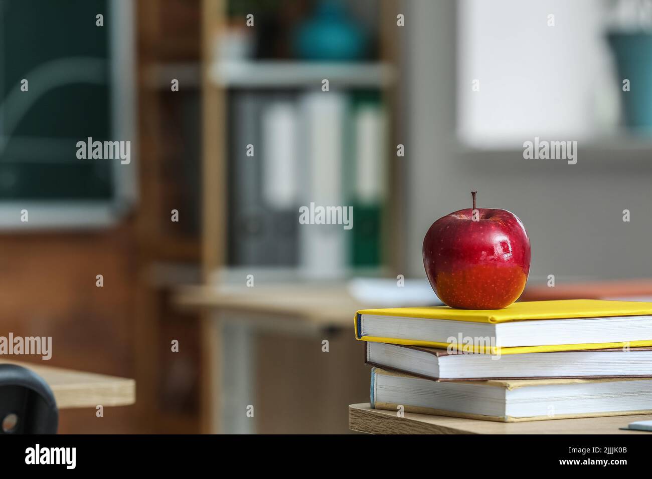 Red apple with school books on table in classroom Stock Photo - Alamy
