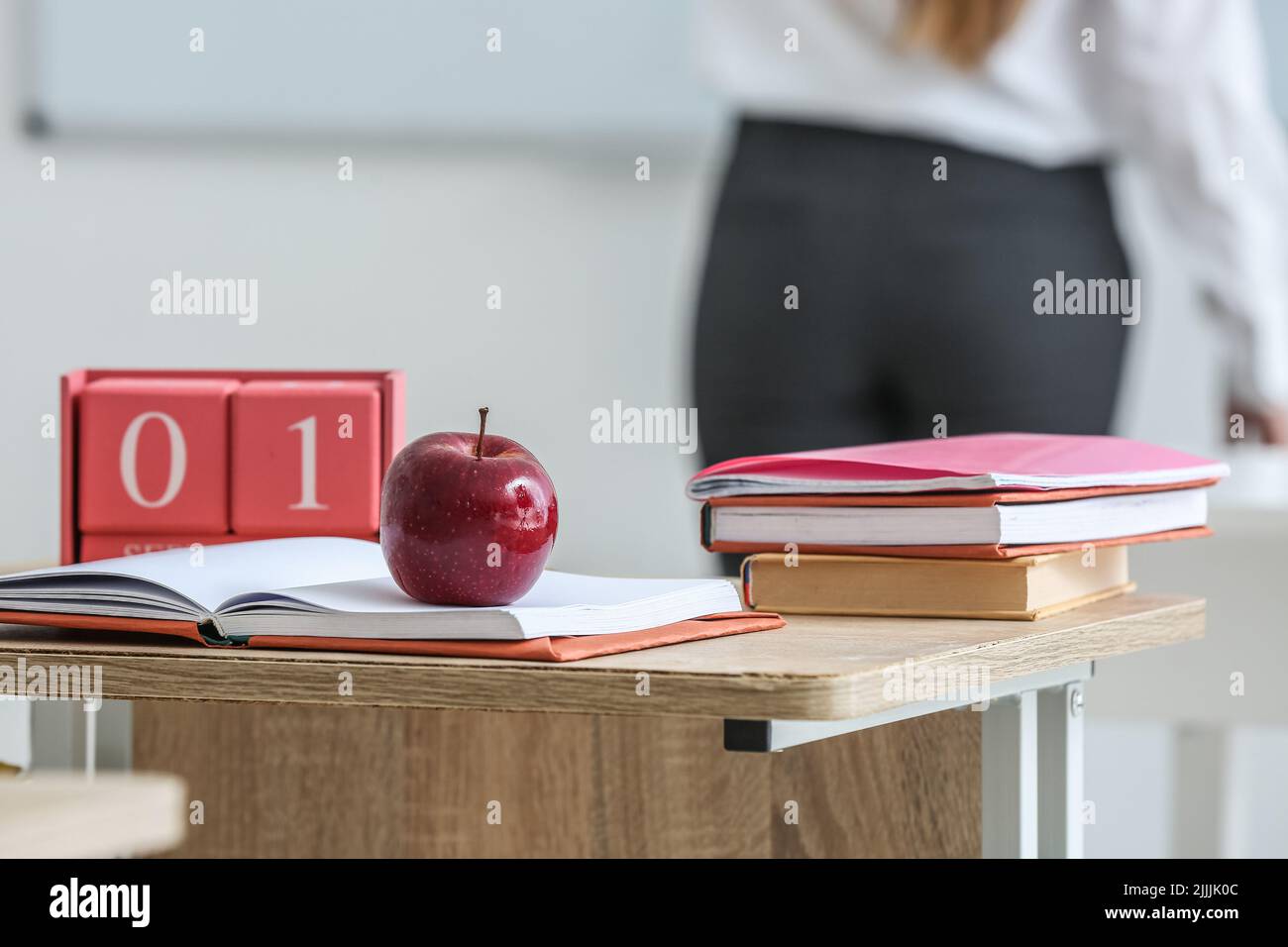 Cube calendar with date 1 SEPTEMBER, apple and school books on table in ...
