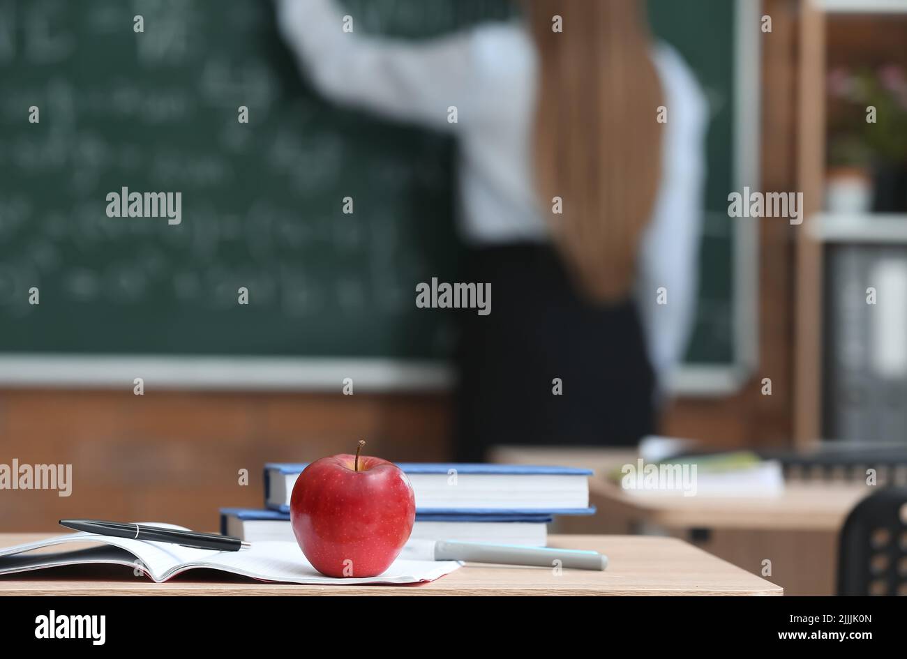 Red apple with books on table in classroom Stock Photo - Alamy