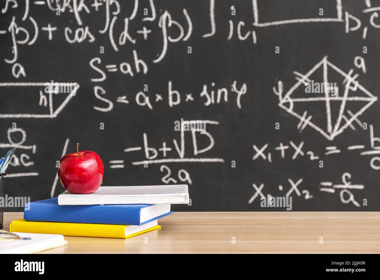 Red apple with school books on table near blackboard Stock Photo - Alamy