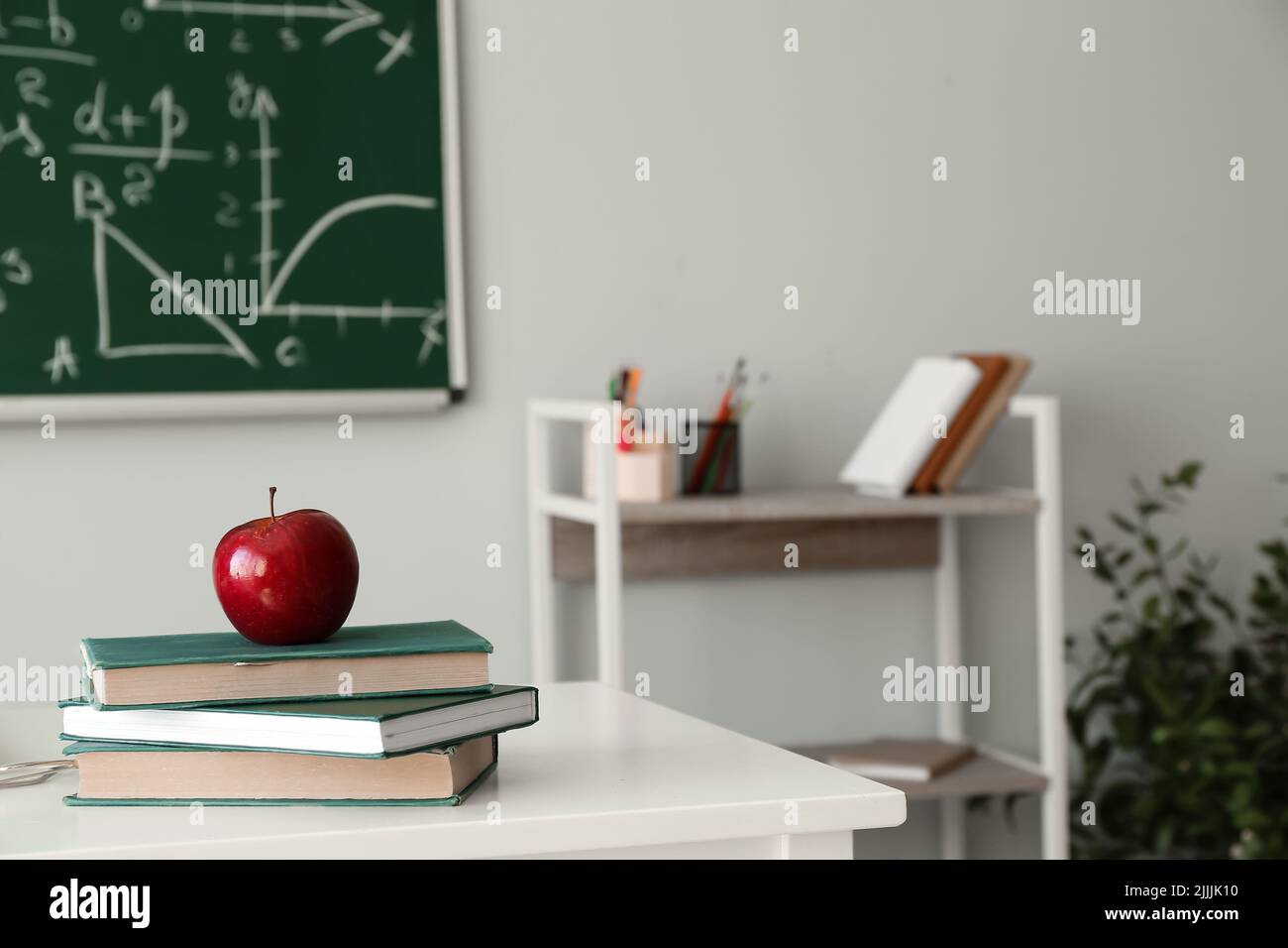 Red apple with school books on table in classroom Stock Photo - Alamy